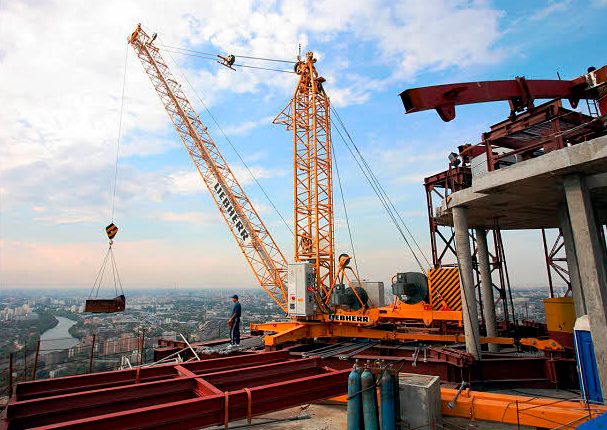 Liebherr 200 DR 5/10 Litronic derrick crane disassembles luffing-jib crane from high-rise roof ...